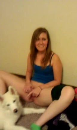 Smiling babe lets the dog lick her pussy on the floor
